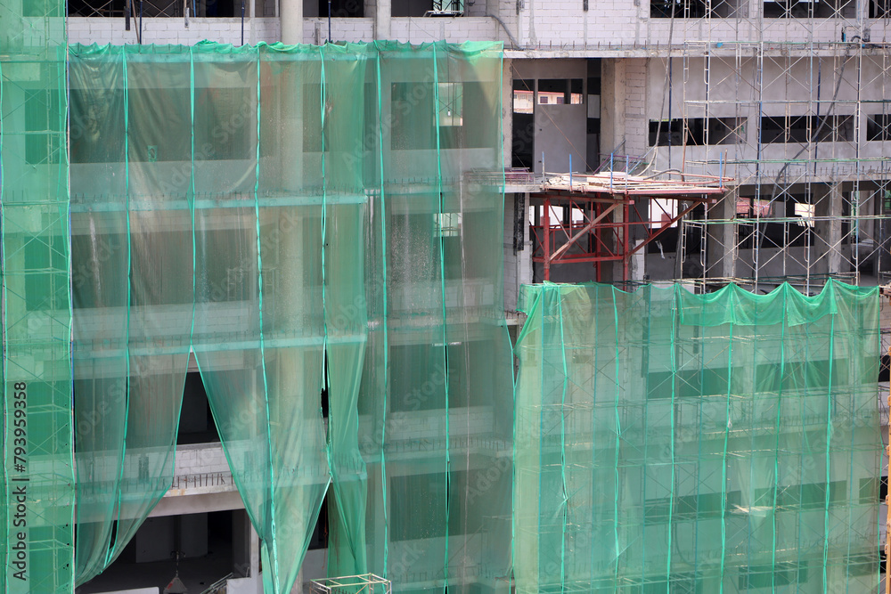 High-rise buildings under construction have coverings to prevent debris ...