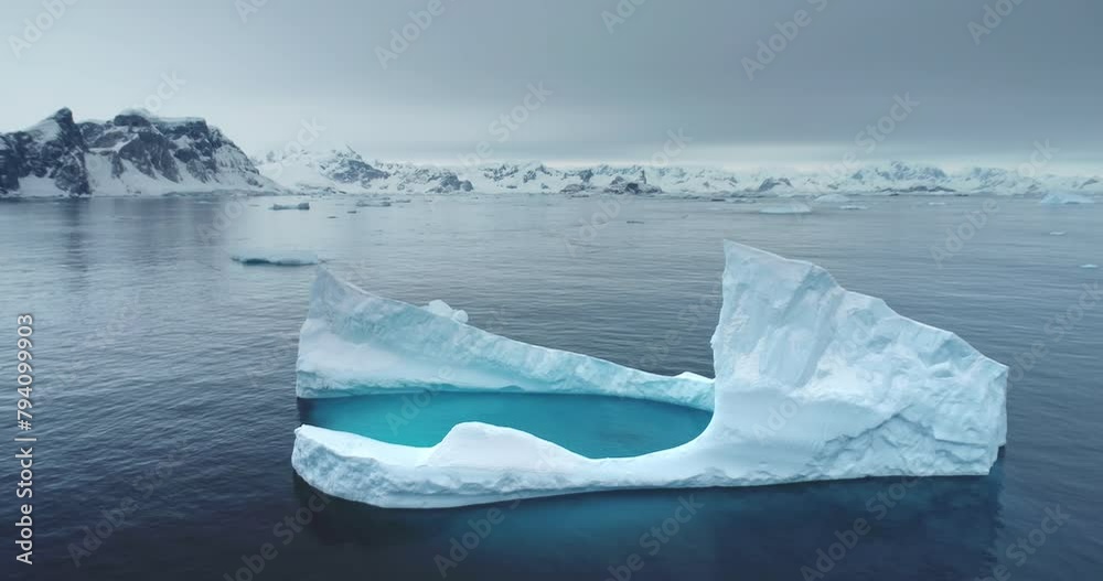 Antarctic melting iceberg floating in cold blue water, aerial. Snow ...