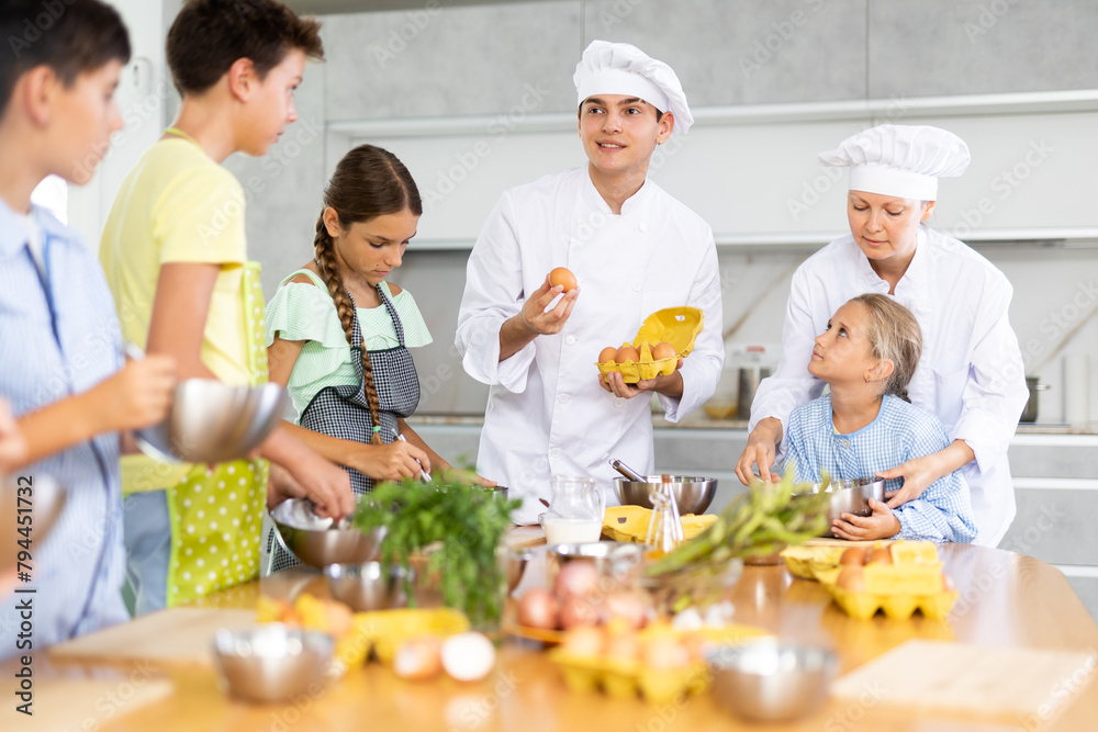 Positive woman and guy, professional chefs in white uniform conducting ...