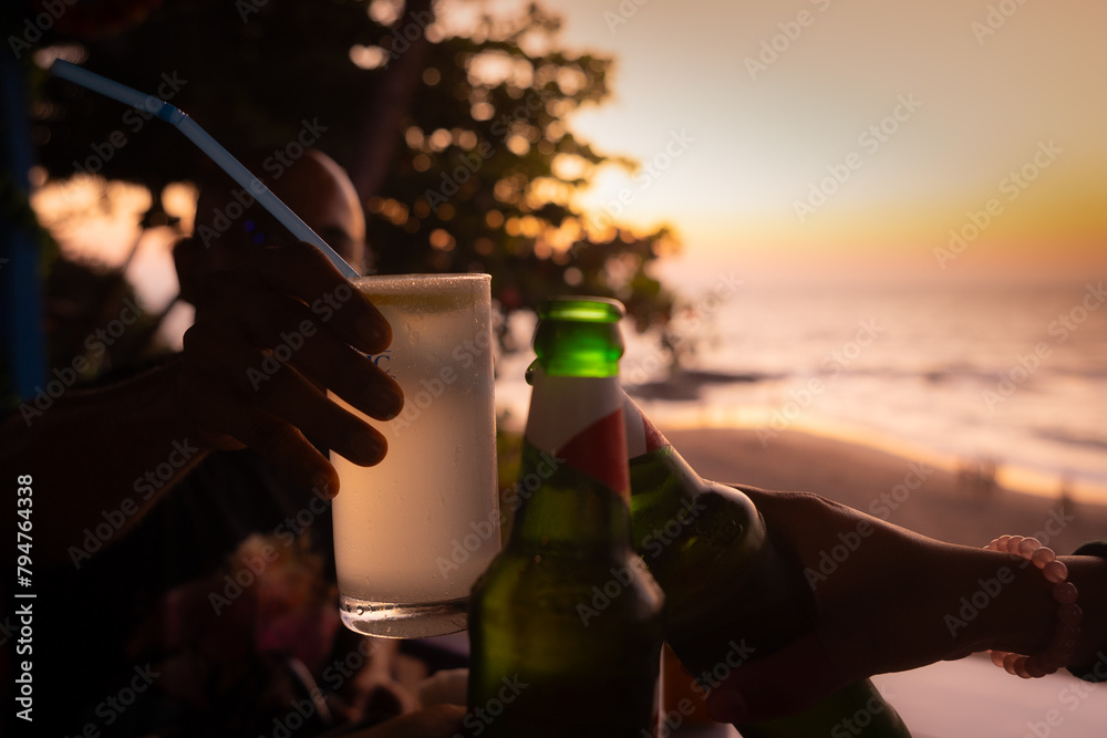 Group of happy friends cheering with tropical cocktails & beers at ...