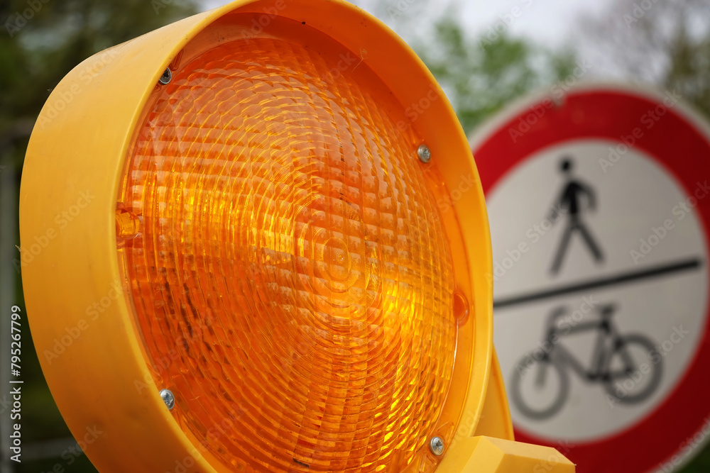 Orange roadworks refelctive lamp with blurred no entry sign in ...