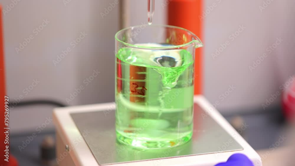 Vidéo Stock Chemical measuring cup with circulating transparent green ...