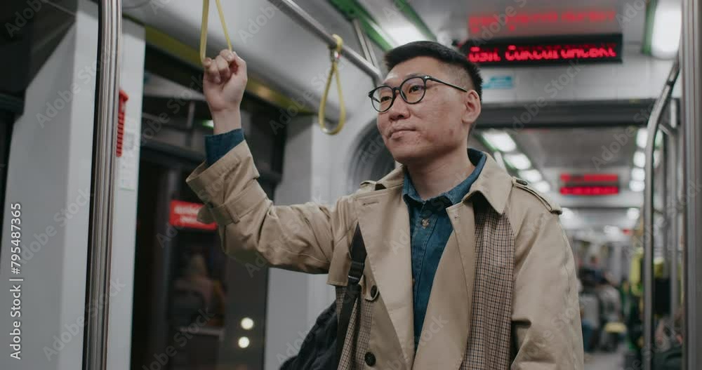 Handsome Chinese male commuting back home after difficult working day ...