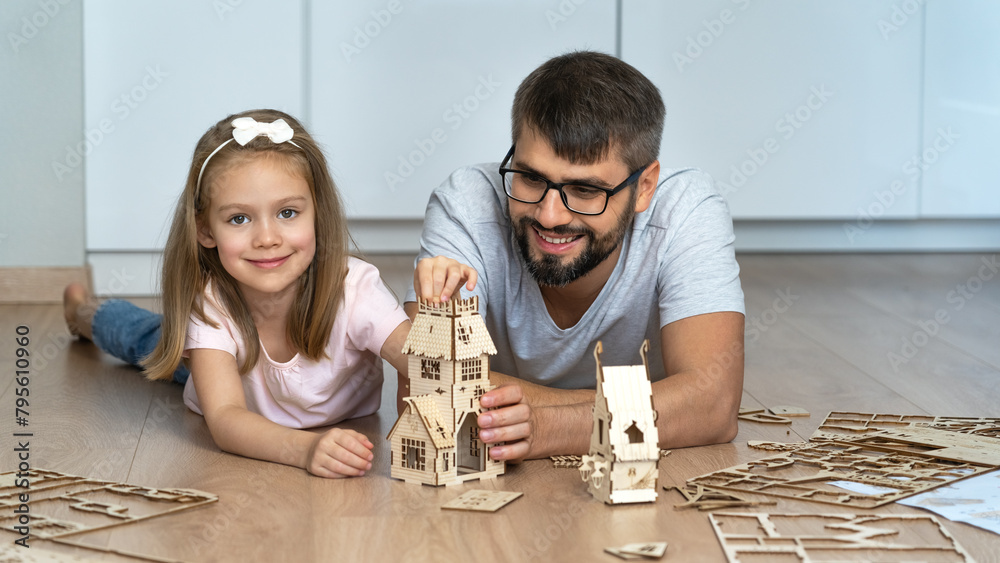 Happy father and child look at camera and laugh building wooden ...