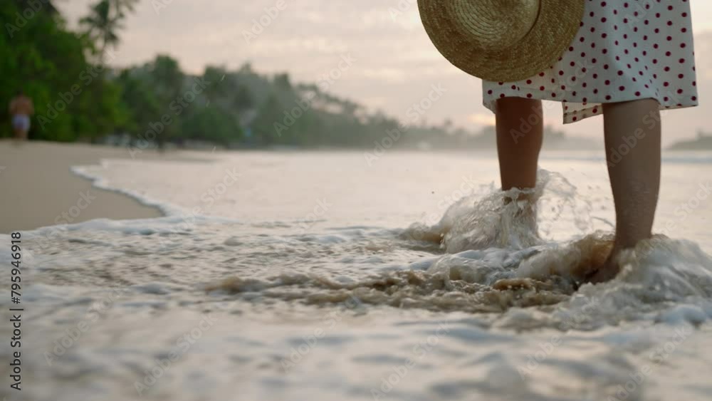 Female feet going barefoot in sea surf water edge at sunset. Splashing ...