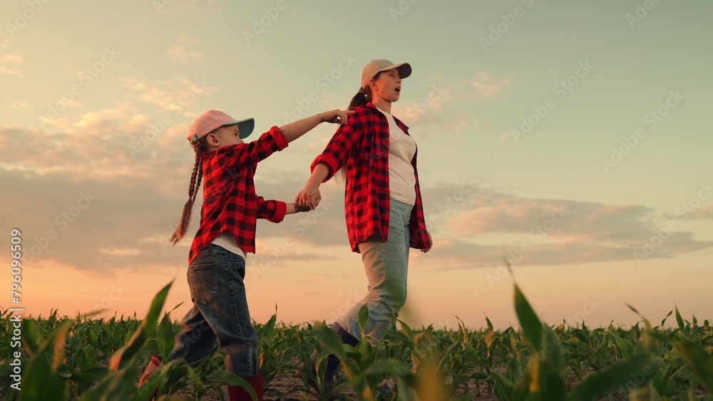 Happy farmers, mom, daughter go field, holding hands. Child, kid points ...
