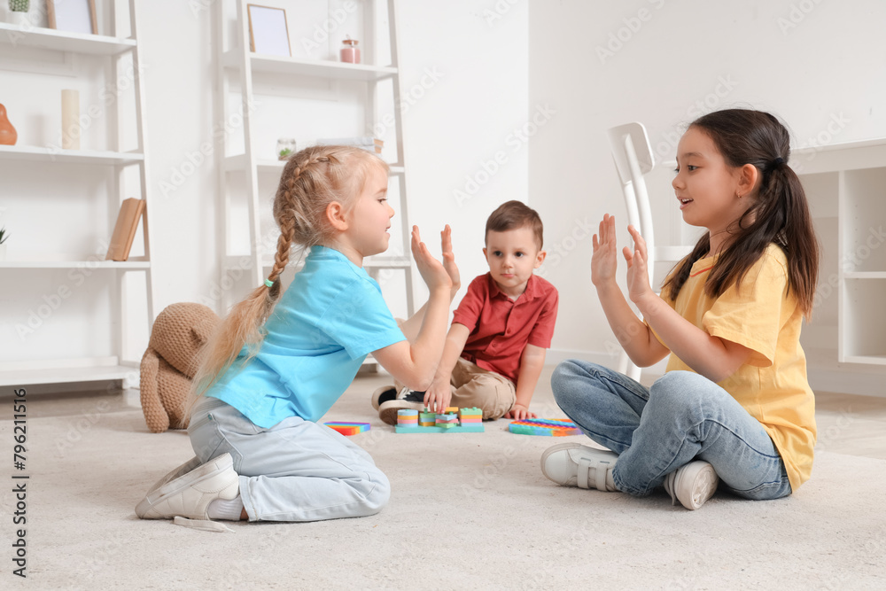 Lonely little boy with autistic disorder and girls playing at home ...