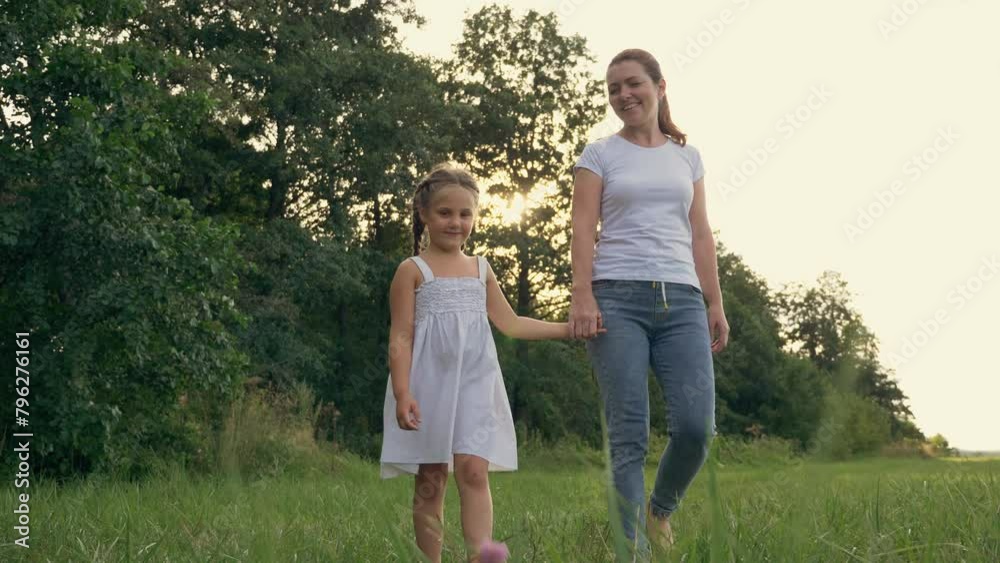 happy family. Mom, daughter are walking in park in fresh air in sun ...