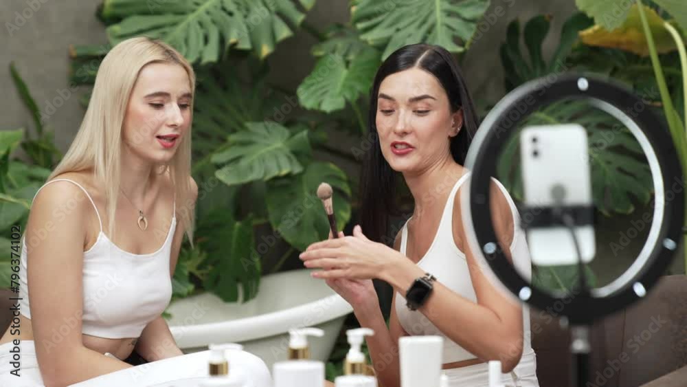 Two beautiful content creator making natural beauty and cosmetic tutorial on green plant leave ...