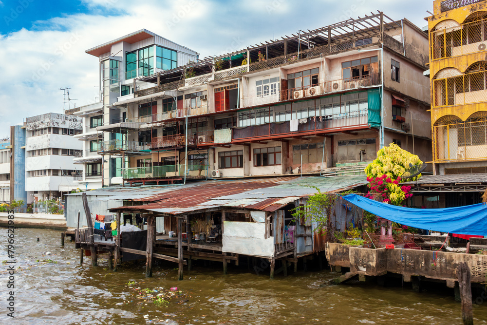 Cityscape with collapsing wooden residential slums on stilts against ...