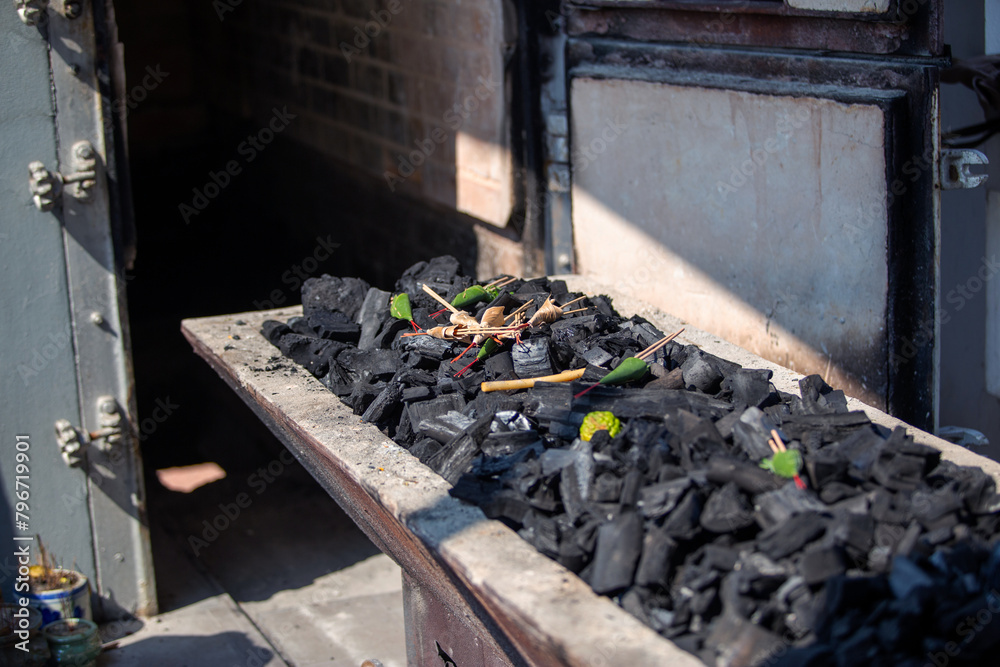 The crematory tray with incense sticks, flower and charcoal from ...