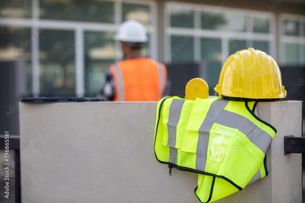 Yellow safety helmet are provided along with reflective vests for ...