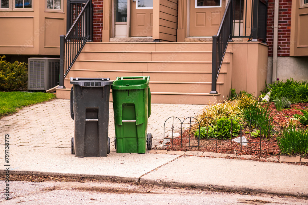 empty green recycling bin and black garbage bin sitting empty on a ...