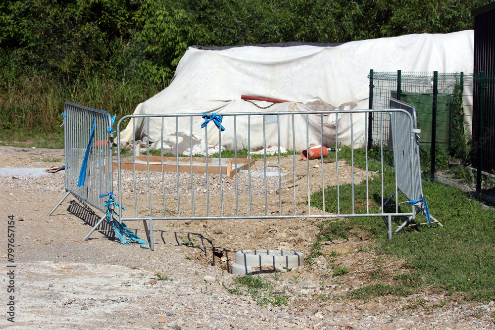 Temporary construction metal fence panels preventing access to open ...