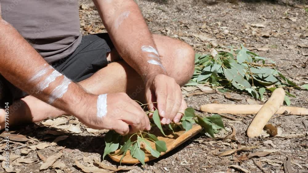 Australian Aboriginal Smoking Ceremony, man preparing green leaves on a ...