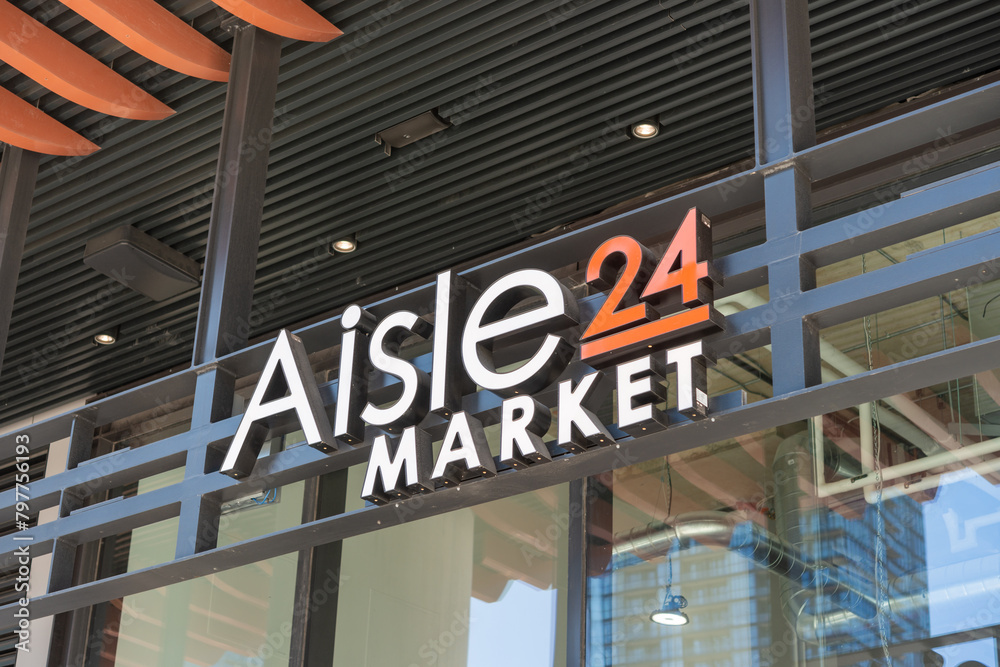 exterior building and sign of Aisle 24 Market, a grocery store, located ...
