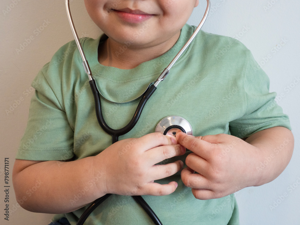 fat kid put green tight shirt listens to the lungs and heart with ...