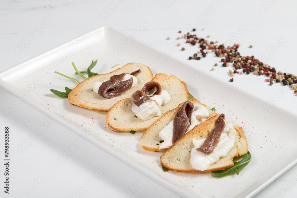 Tasty slices of bread with butter and salted anchovy fillets ...