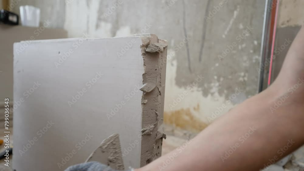 Partition made of tongue-and-groove slabs. A mason applies cement ...