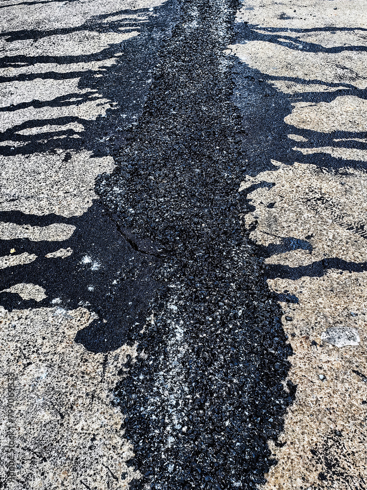 Asphalt on road. Street with black tar filling the cracks. Cracks in ...