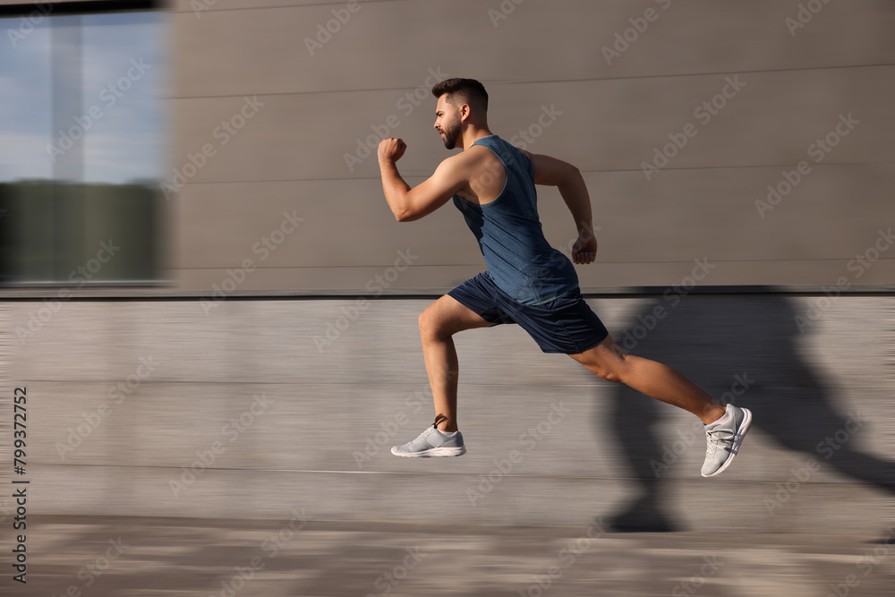 Sporty young man running on street. Motion blur effect showing his ...