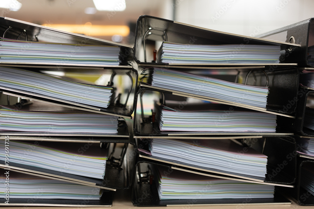 Files stacked on filing cabinet. A large pile of binders filled with ...