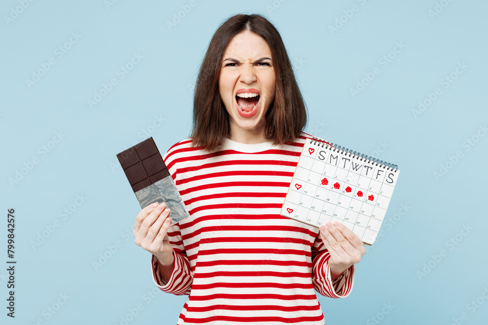 Young angry mad woman she wears red casual clothes eat sweet chocolate ...