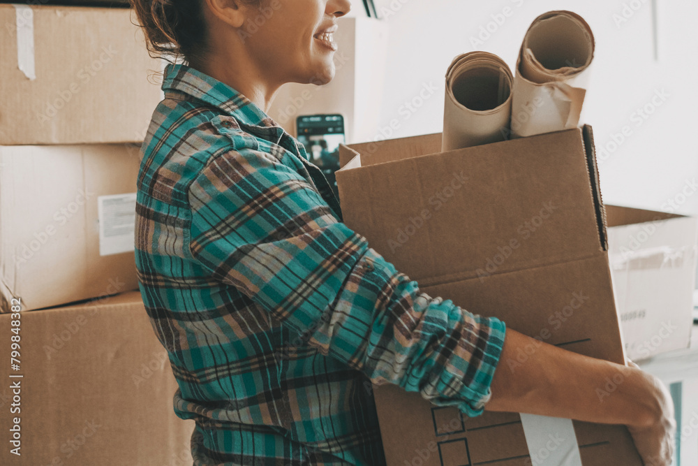 Happy adult woman relocating house lifting cardboard box with life ...
