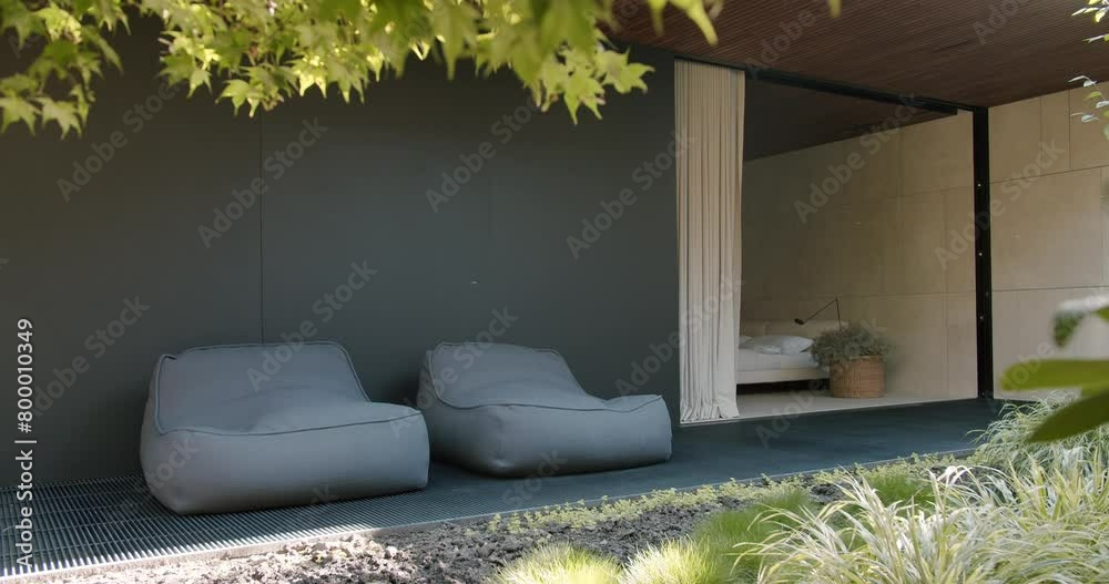 Elegant modern home exterior featuring a relaxing lounge area with two ...