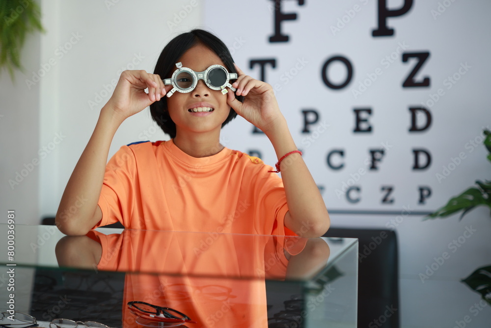 Elementary school girl wearing eyeglasses visual acuity test with test ...