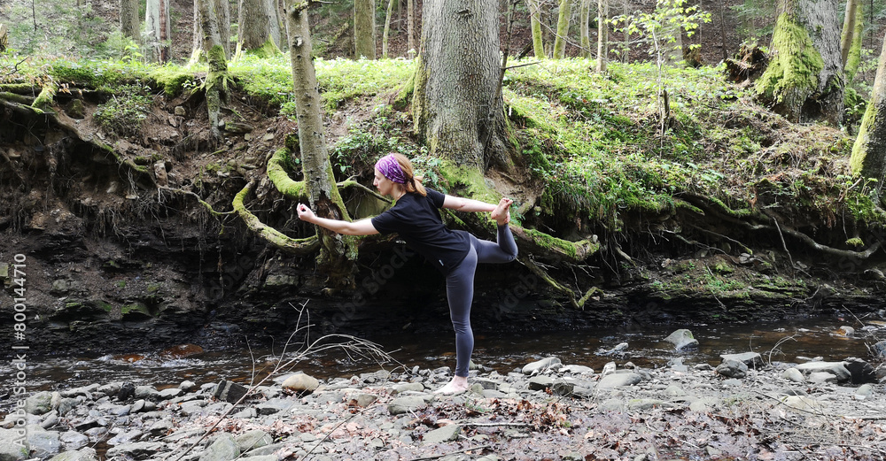 Yoga in nature. Girl in middle of forest conducts a retreat for herself ...