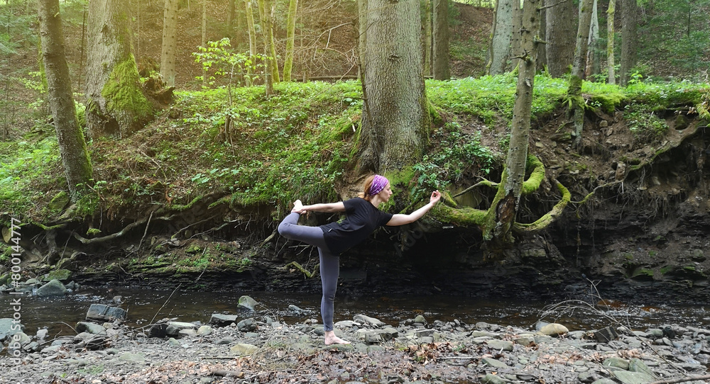 Yoga in nature. Girl in middle of forest conducts a retreat for herself ...