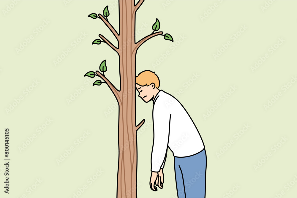 Tired man rests forehead on tree to rest after long walk in fresh air ...