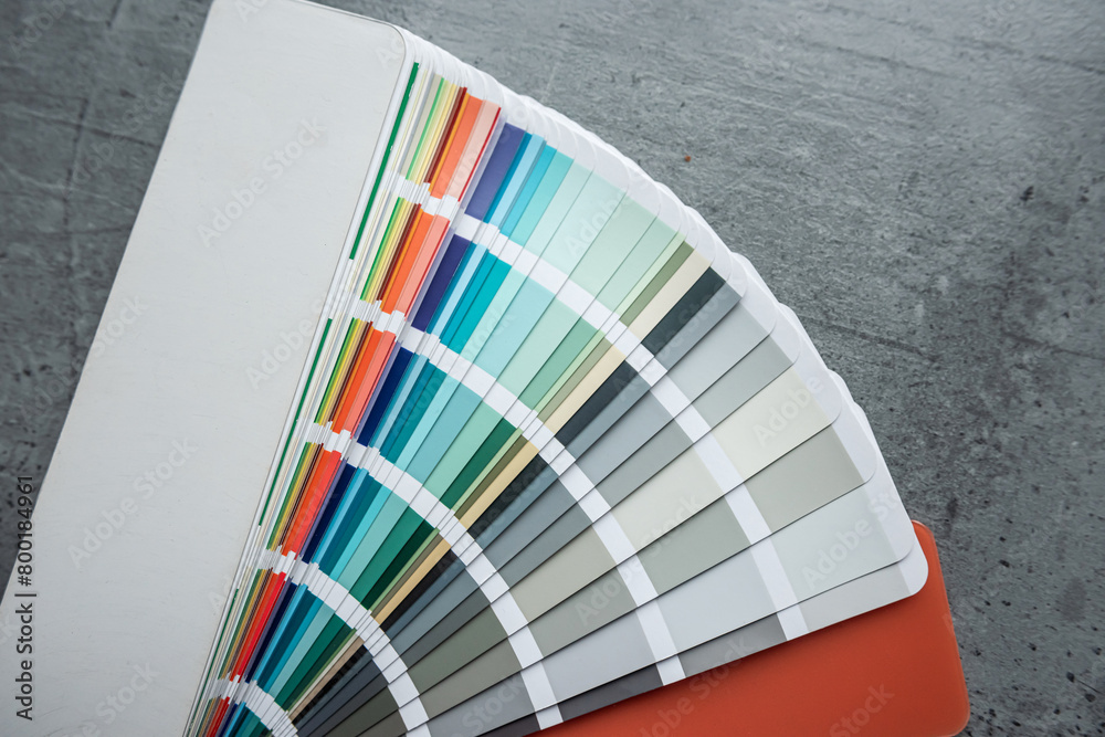 Rainbow catalog of paints with a various color palette on grey desk ...