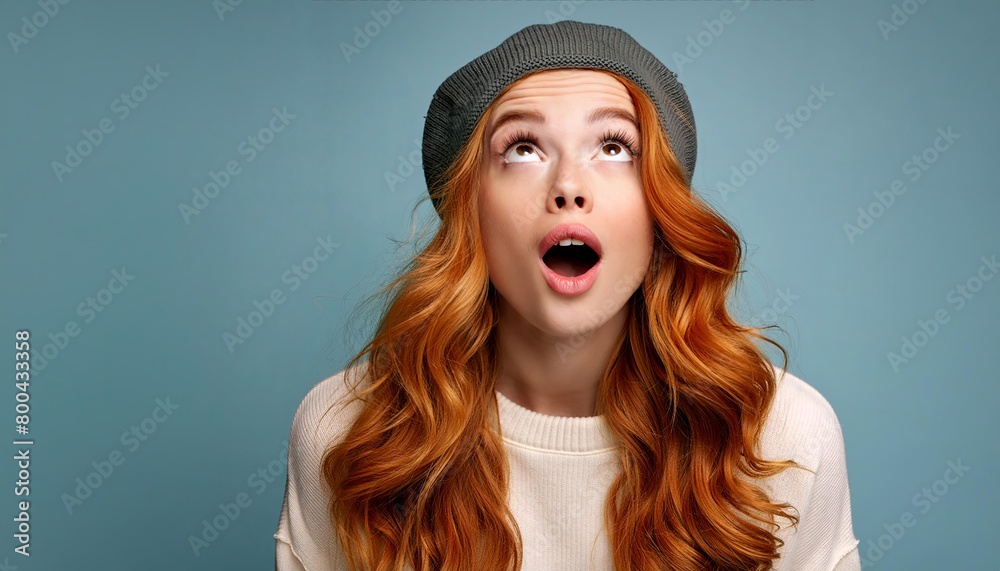 Surprised redhead woman with beret on isolated background, looking at ...