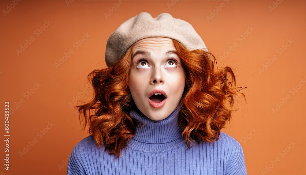 Surprised redhead woman with beret on isolated background, looking at ...