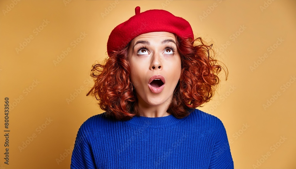 Surprised redhead woman with beret on isolated background, looking at ...