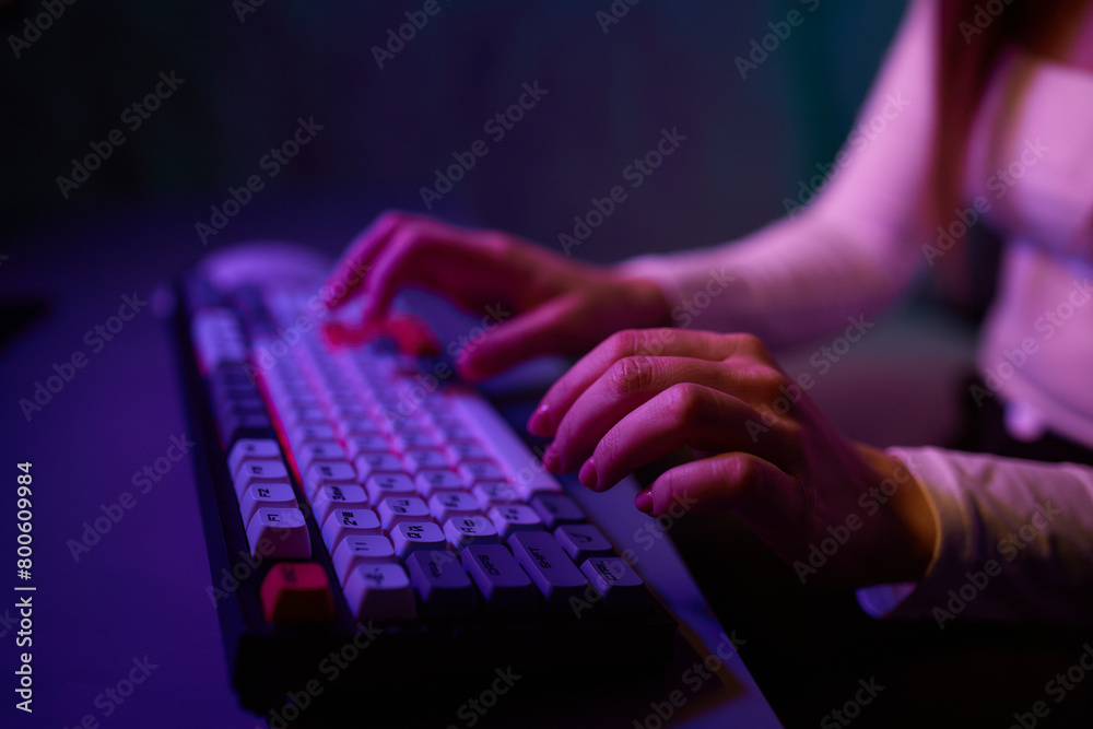 Professional online gamer hand fingers mechanical keyboard in neon ...