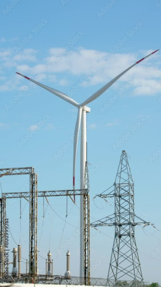 Wind machine produces renewable energy against blue sky. Large turbine ...