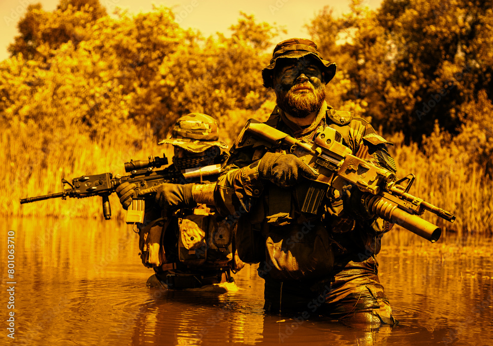 Soldiers move in the heart of a marsh, crossing swampy waters, tropical ...