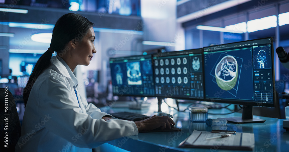 Female Asian Neuroscientist Using Desktop Computer With Human Brain CT ...