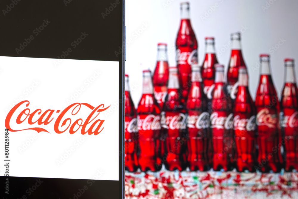Coca-Cola company logo on screen of smartphone against blurred ...