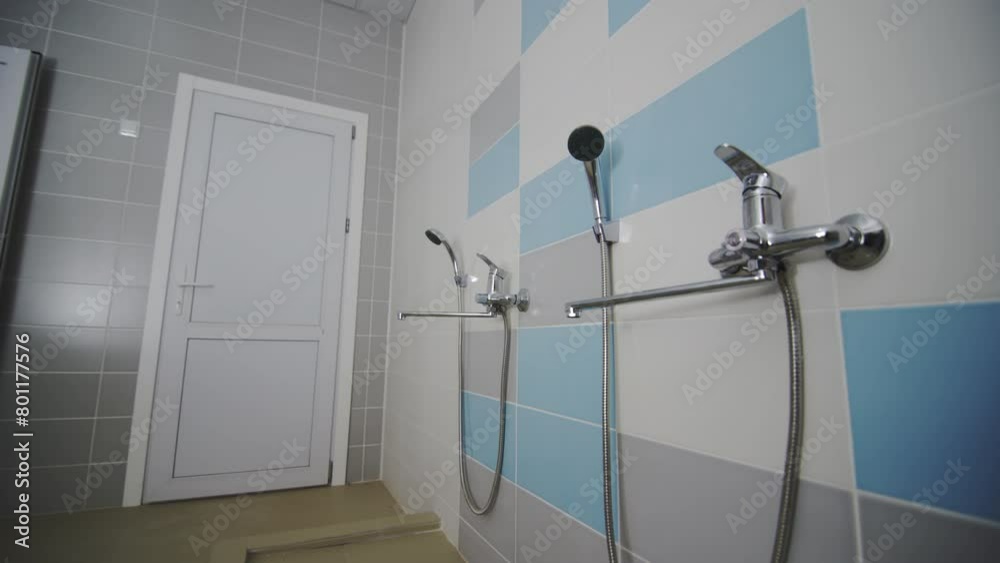 Spacious public shower room with tiles of pale colors in sports center ...