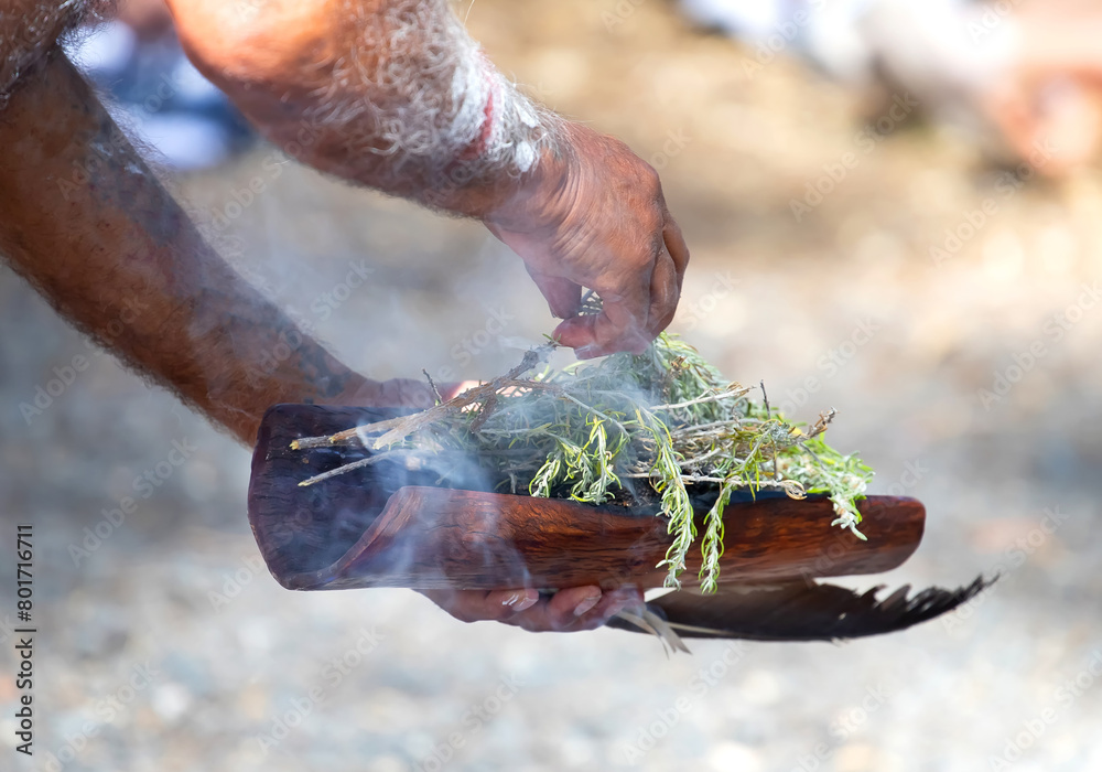 Human hands hold wooden dish with Australian plant branches, the smoke ...