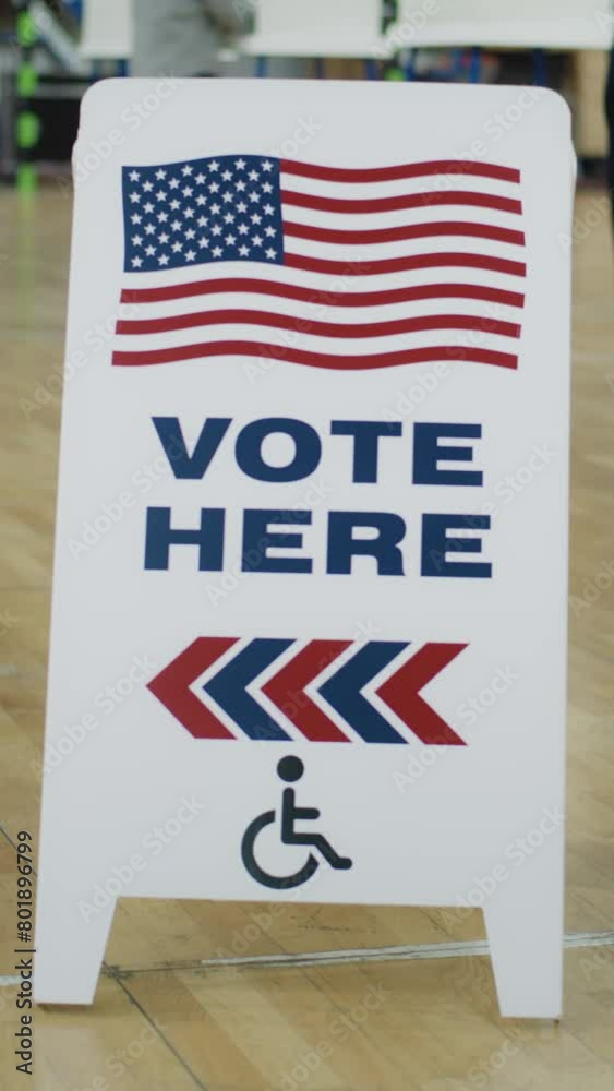 Vote here sign on floor. Woman with spinal muscular atrophy in electric ...