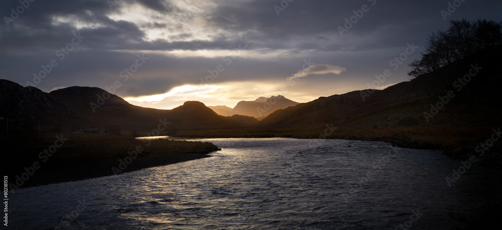 The River Gruinard at sunrise with the distant sun drench summits of ...