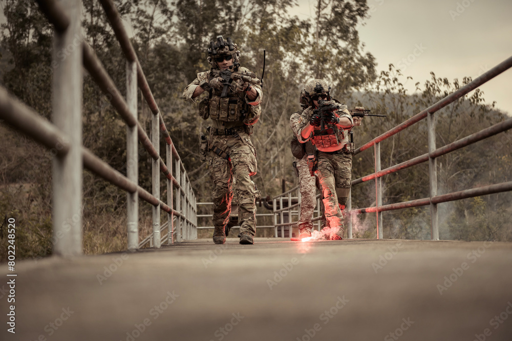 Soldiers in camouflage uniforms aiming with their rifles.ready to fire ...