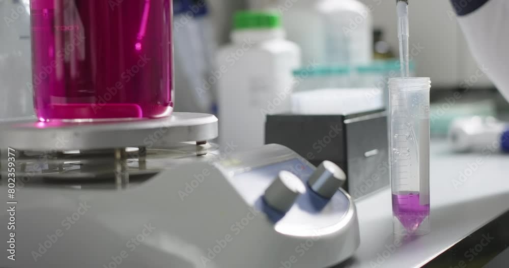 Pharmaceutical laboratory. Purple sample mixing in a magnetic stirrer ...