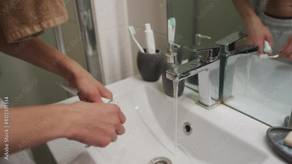 Hungover gen Z man with swollen face taking toothpaste and brushing his ...
