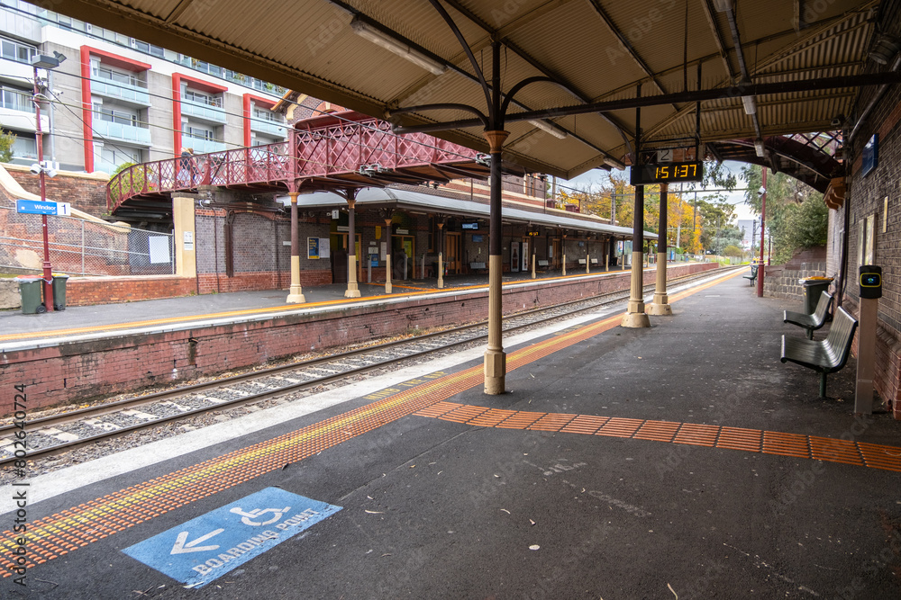 The platform with tactile paving, pedestrian footbridge and a covered ...